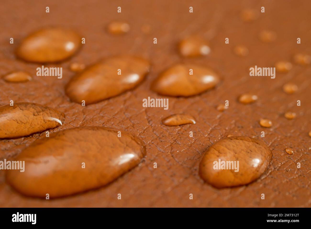Round water drops on brown leather texture, side view, soft focus macro ...