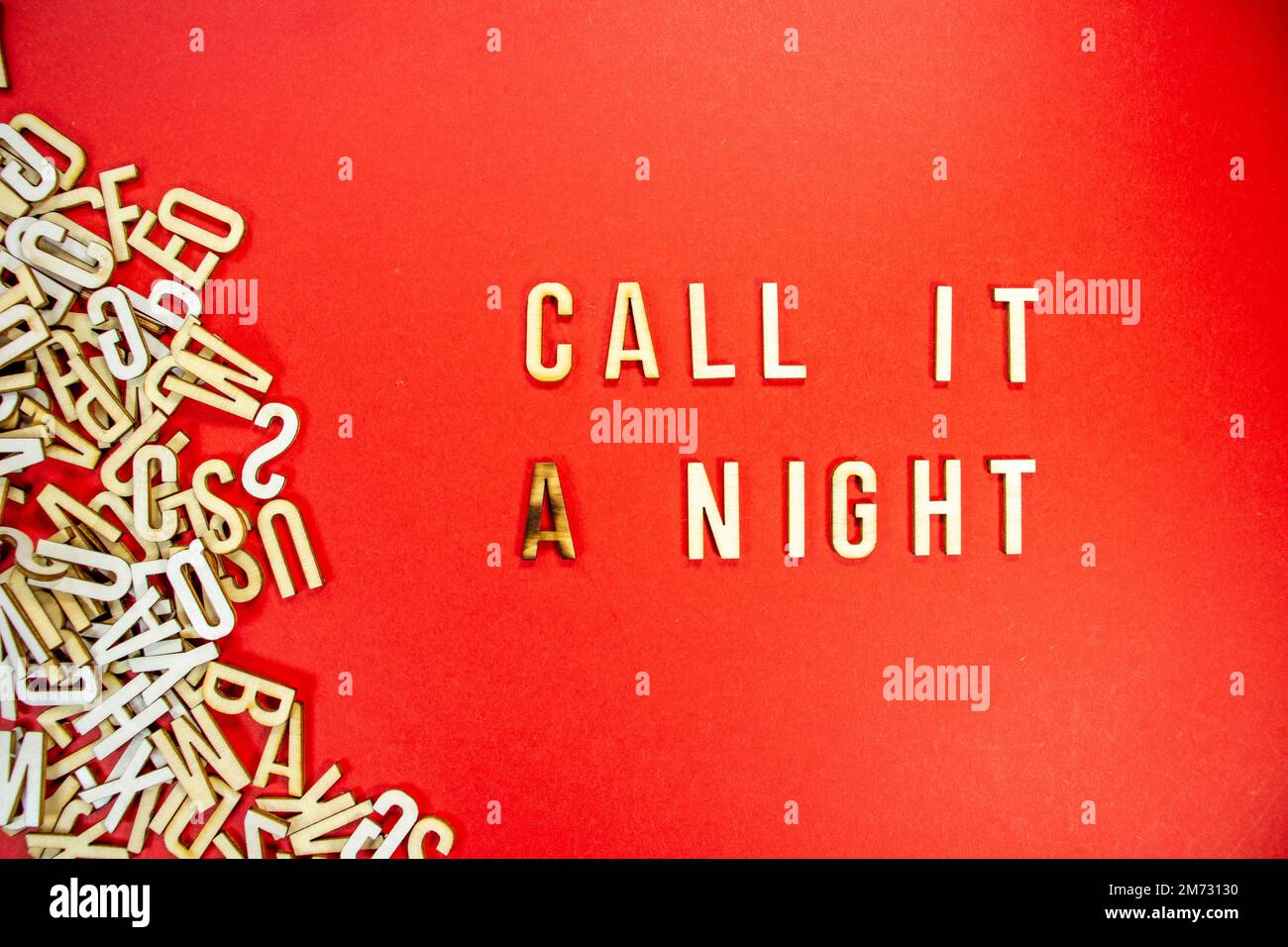 CALL IT A NIGHT in wooden English language capital letters spilling from a pile of letters on a ...