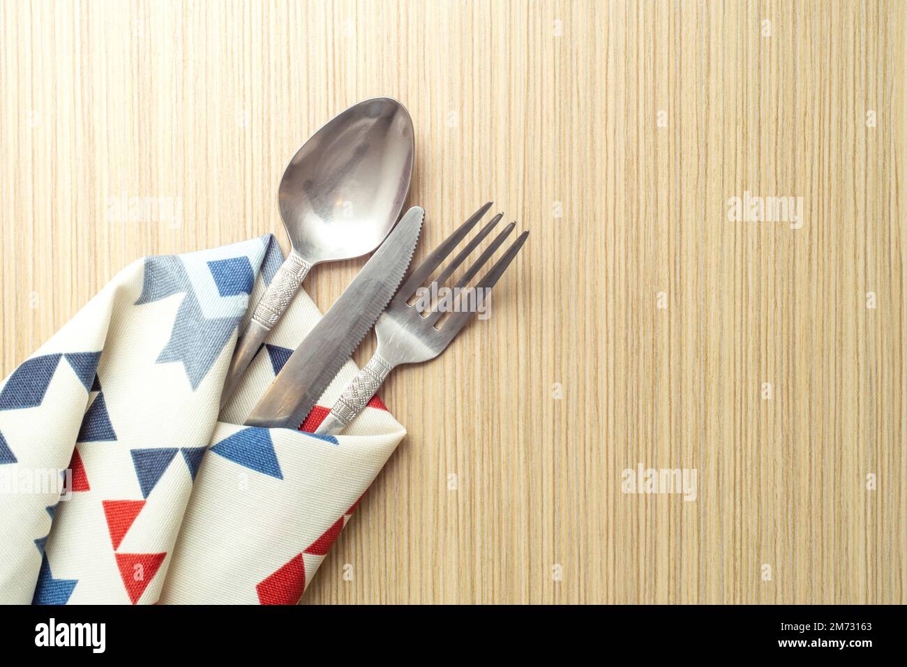 Dinner table backdrop with spoon fork and knife in a patterned fabric ...