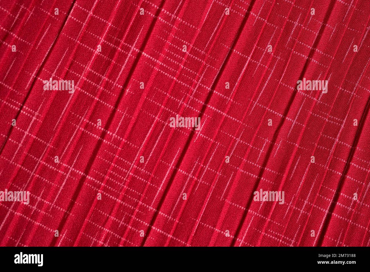 Red synthetic fabric with diagonal straight creases and fine pattern ...