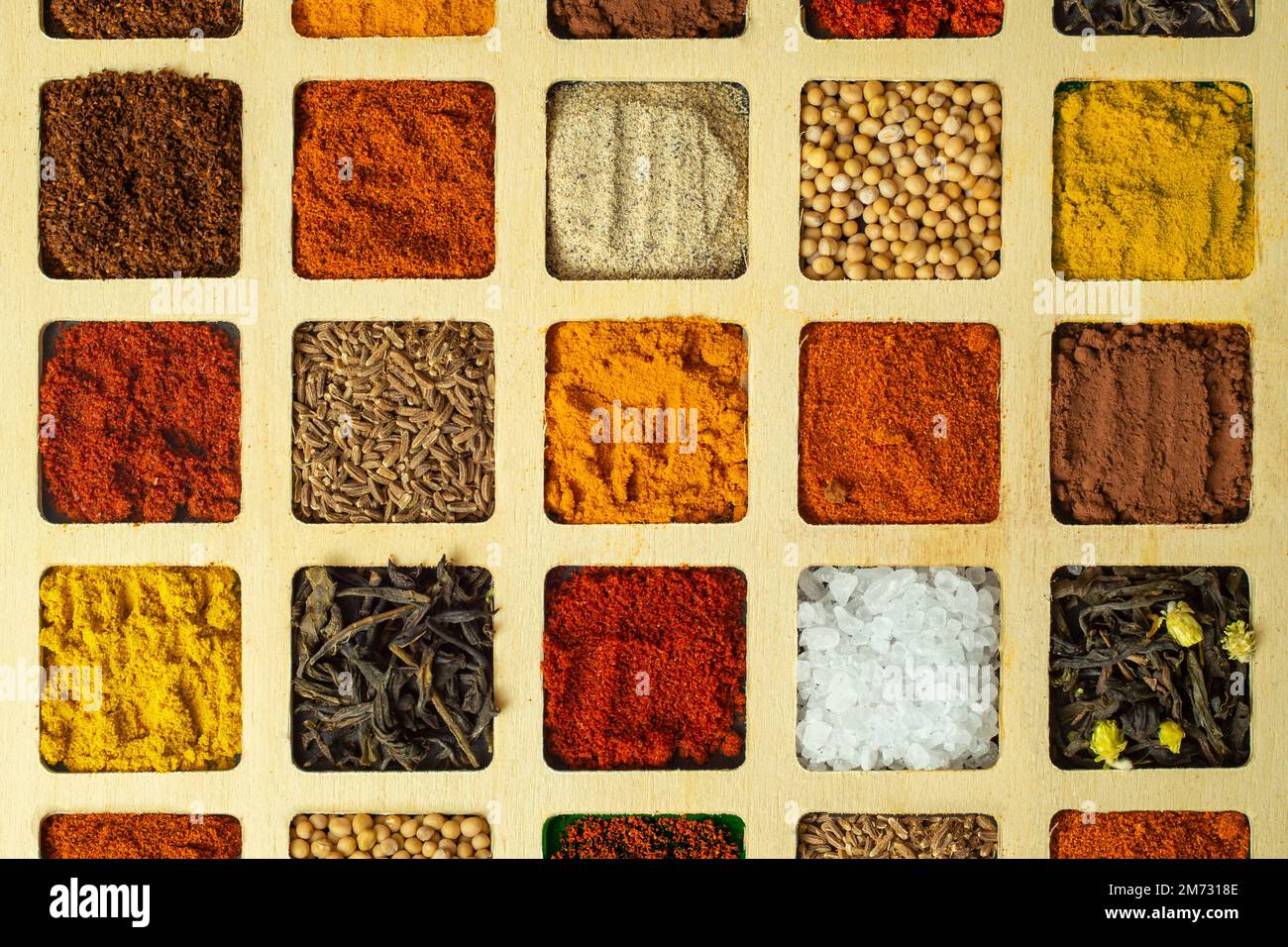 Close up of a colorful selection of spices portioned in square shaped ...