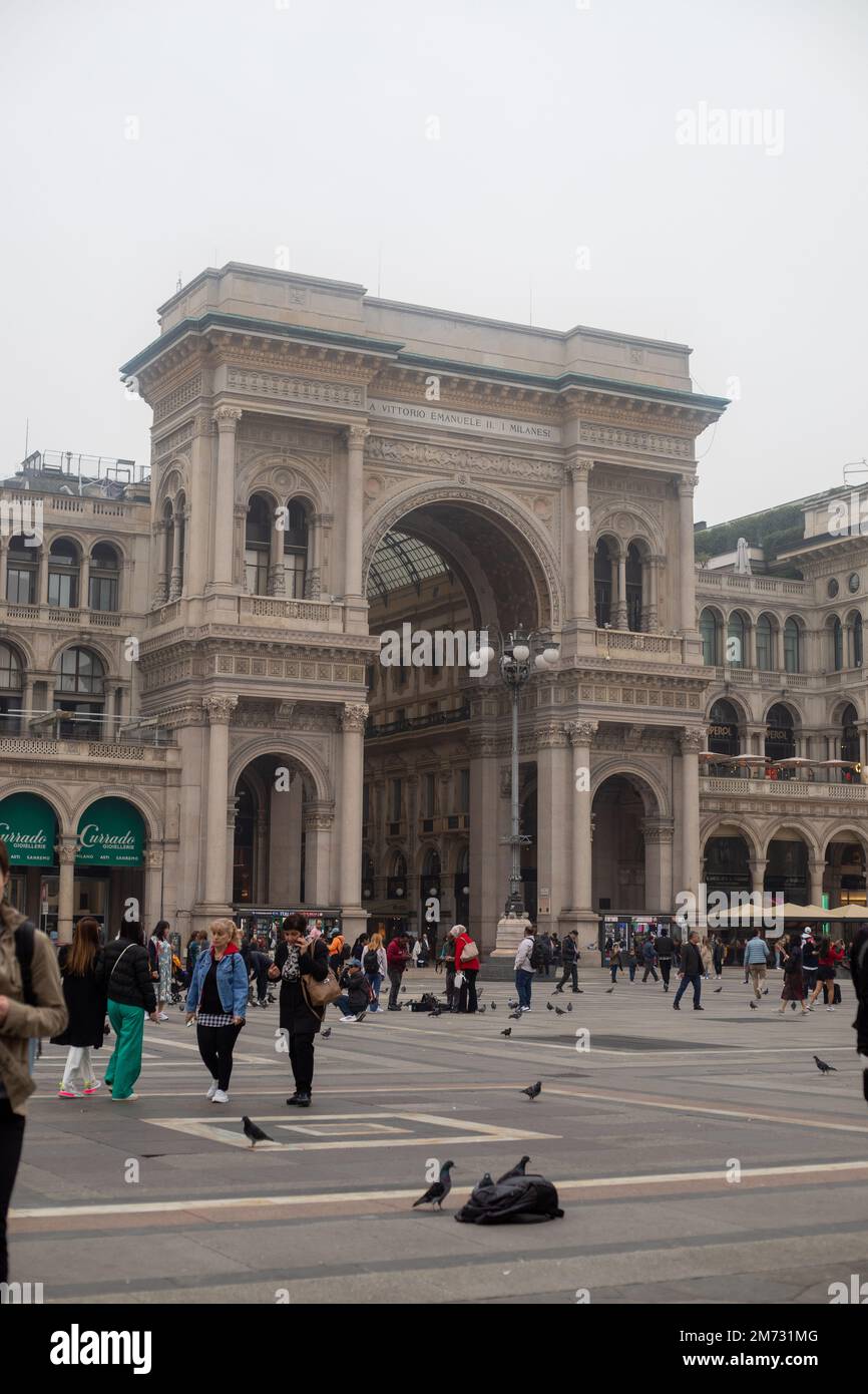 A vertical shot of people walking near modern buildings in Milan, Italy ...