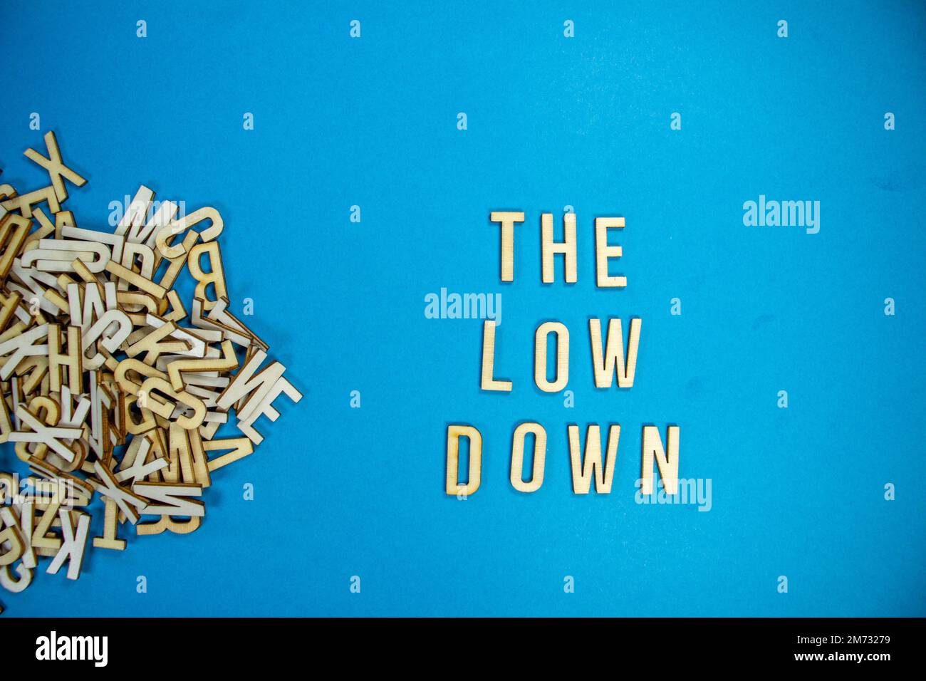 THE LOW DOWN in wooden English words language capital letters spilling ...