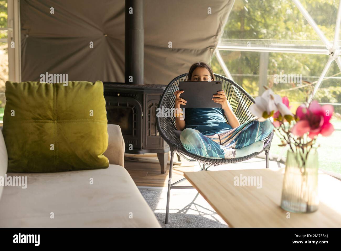 Cute little girl with tablet listening to audiobook at home Stock Photo ...