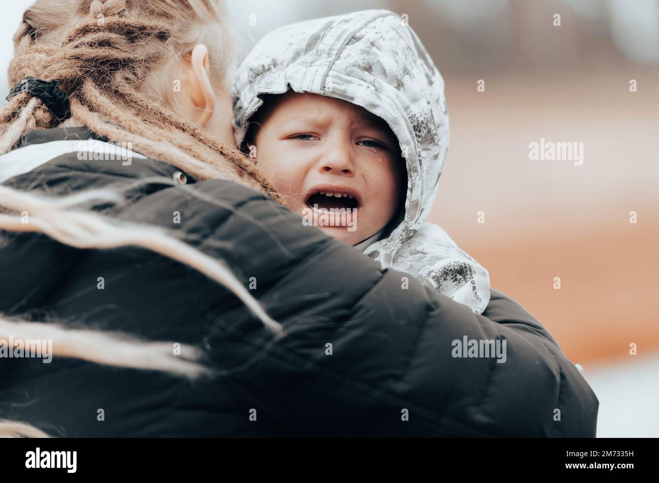 Mother holding crying baby, sad little boy being hugged by his mother ...