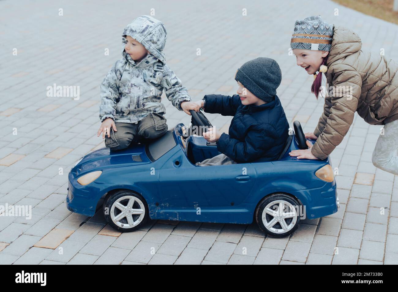 Two happy kids having fun drive a blue toy car, road trip adventure ...