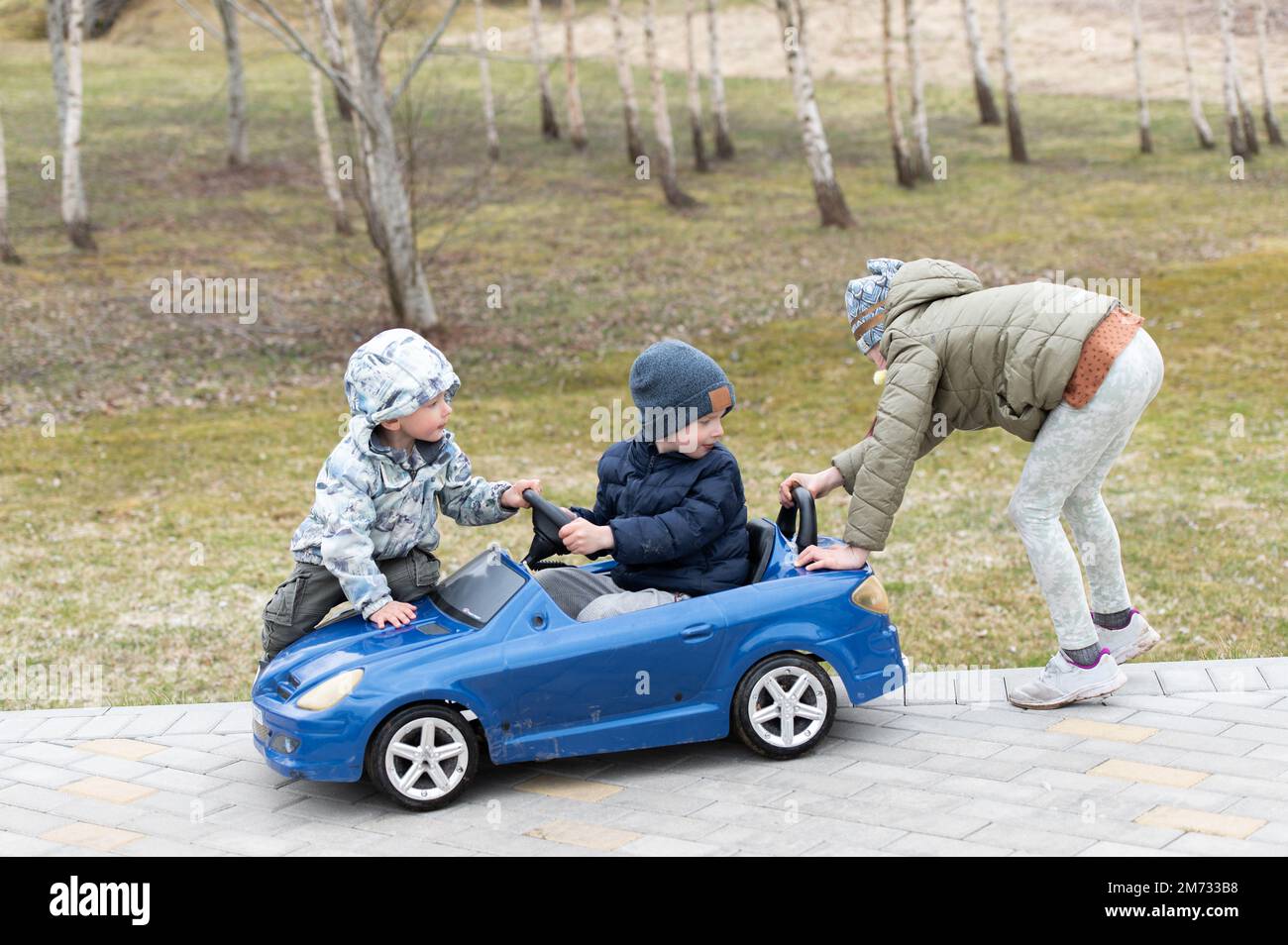Two happy kids having fun drive a blue toy car, road trip adventure ...