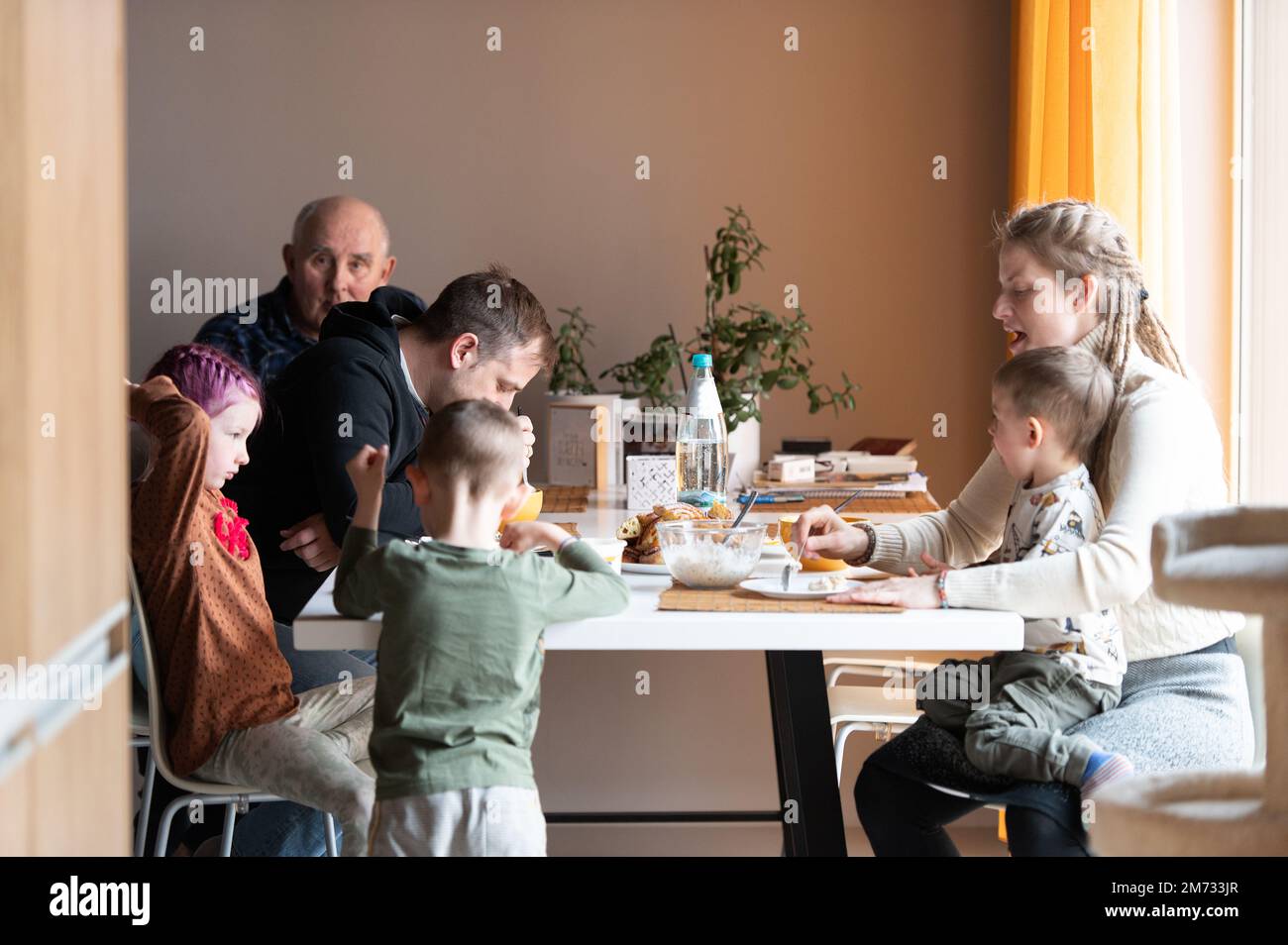 Family kids sitting around table hi-res stock photography and images ...