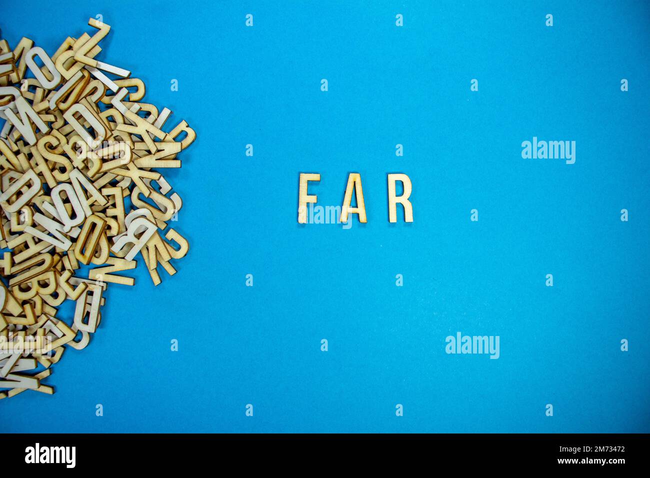 FAR in wooden English words language capital letters spilling from a ...