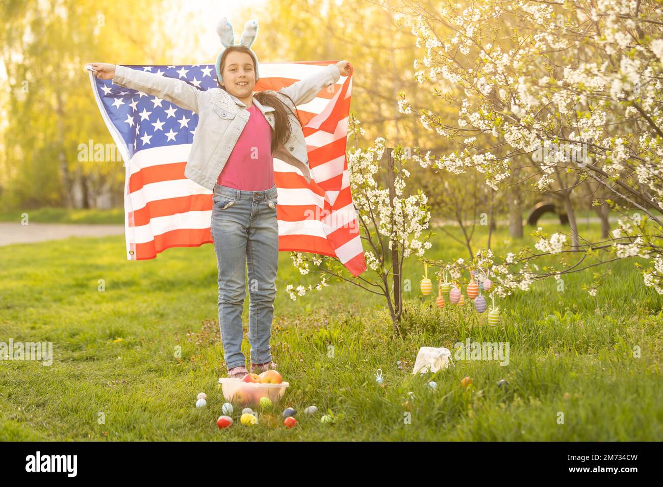 Girl kid in rabbit bunny ears on head with colored eggs and american ...