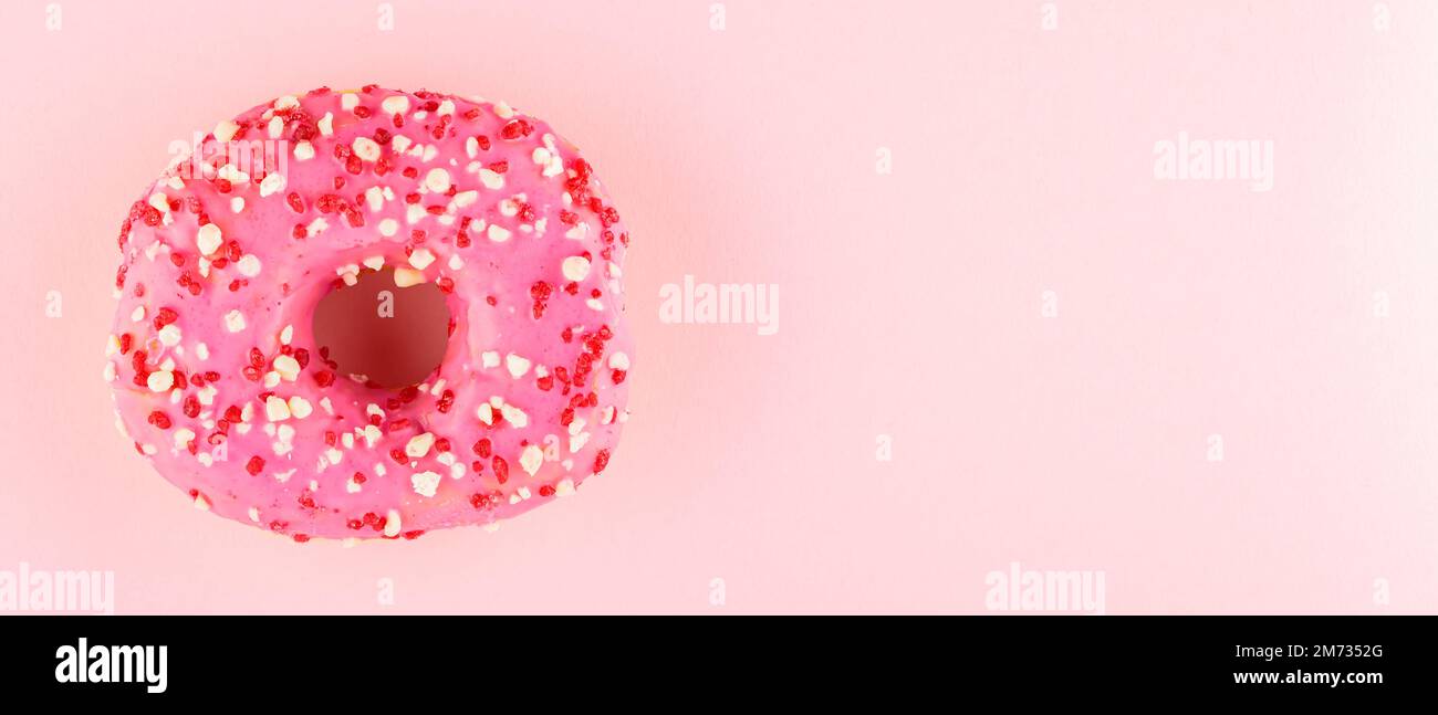 Pink donut with sprinkles on pink pastel background. One sweet pink ...