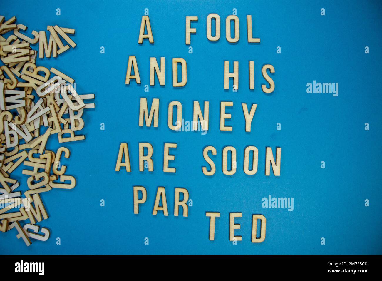A FOOL AND HIS MONEY ARE SOON PARTED in wooden English words language ...