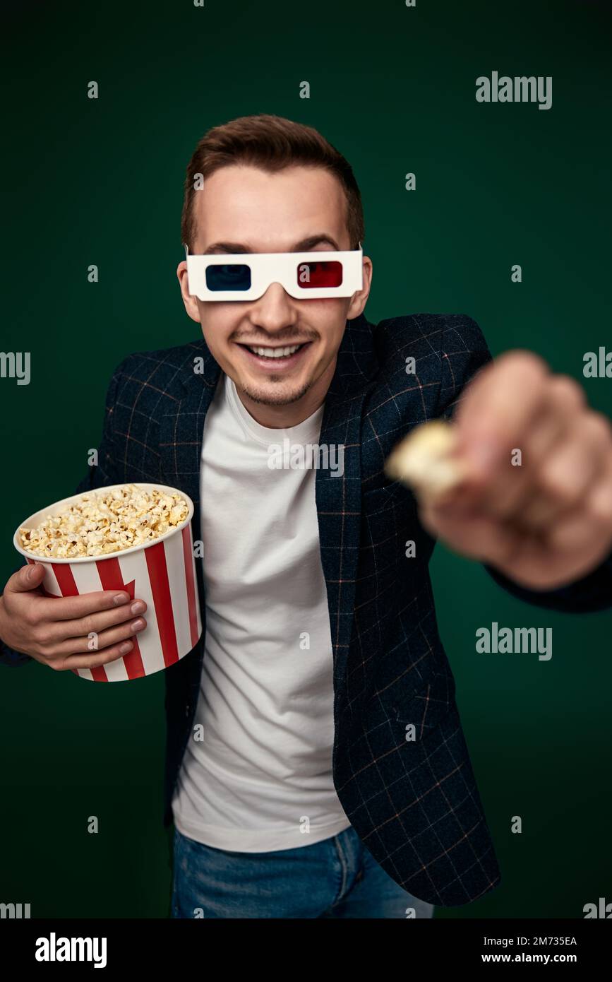 Young caucasian man in 3d glasses eating popcorn Stock Photo - Alamy