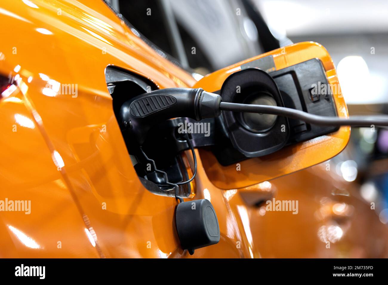 Closeup of power supply plugged into an modern electric car. Electric ...