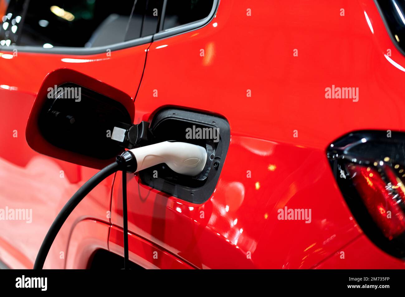 Closeup of power supply plugged into an modern electric car. Electric ...