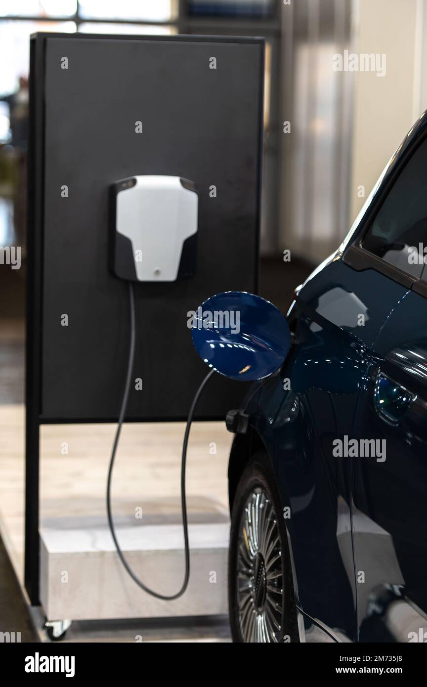 Closeup of power supply plugged into an modern electric car. Electric ...