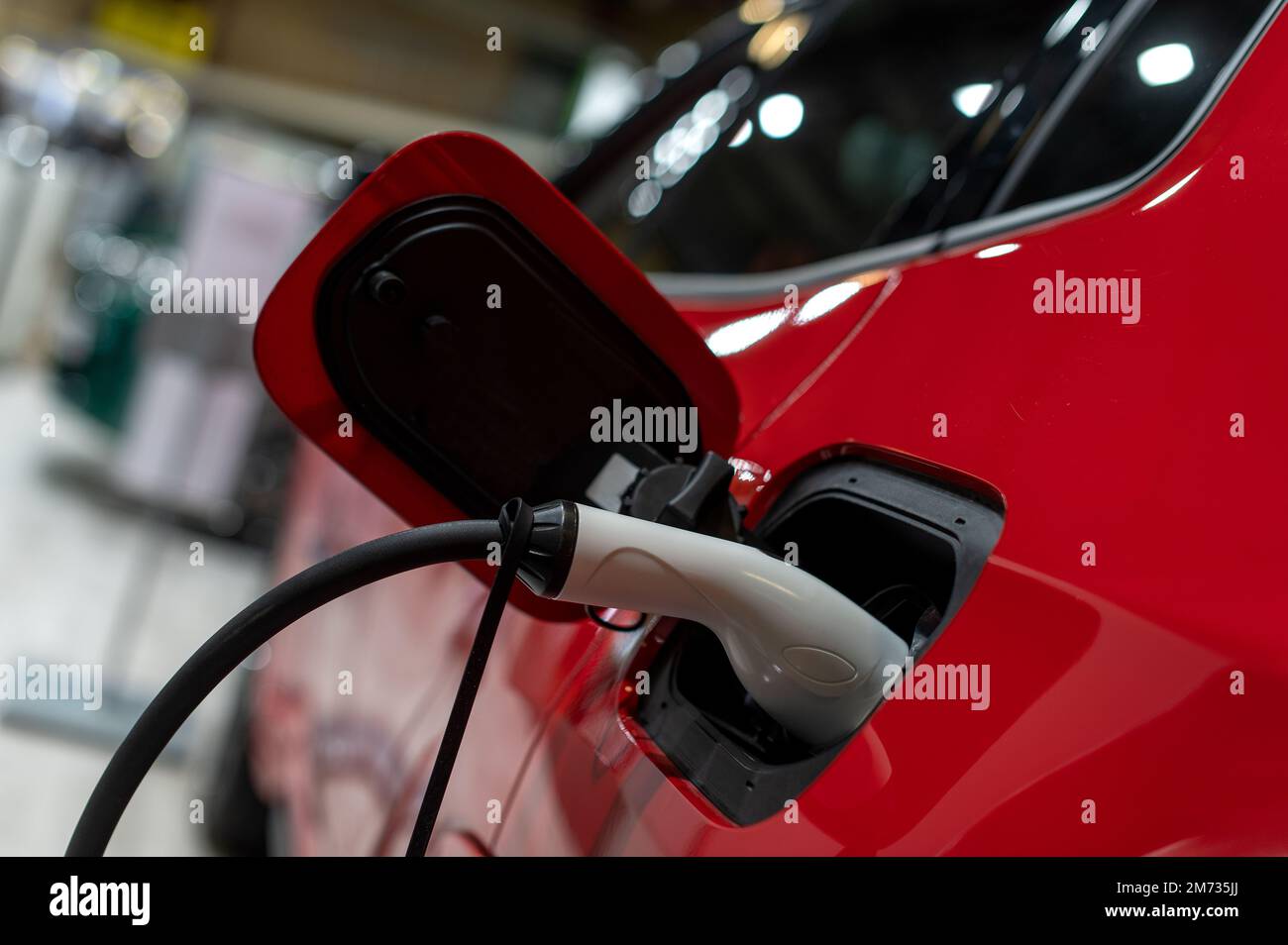 Closeup of power supply plugged into an modern electric car. Electric ...