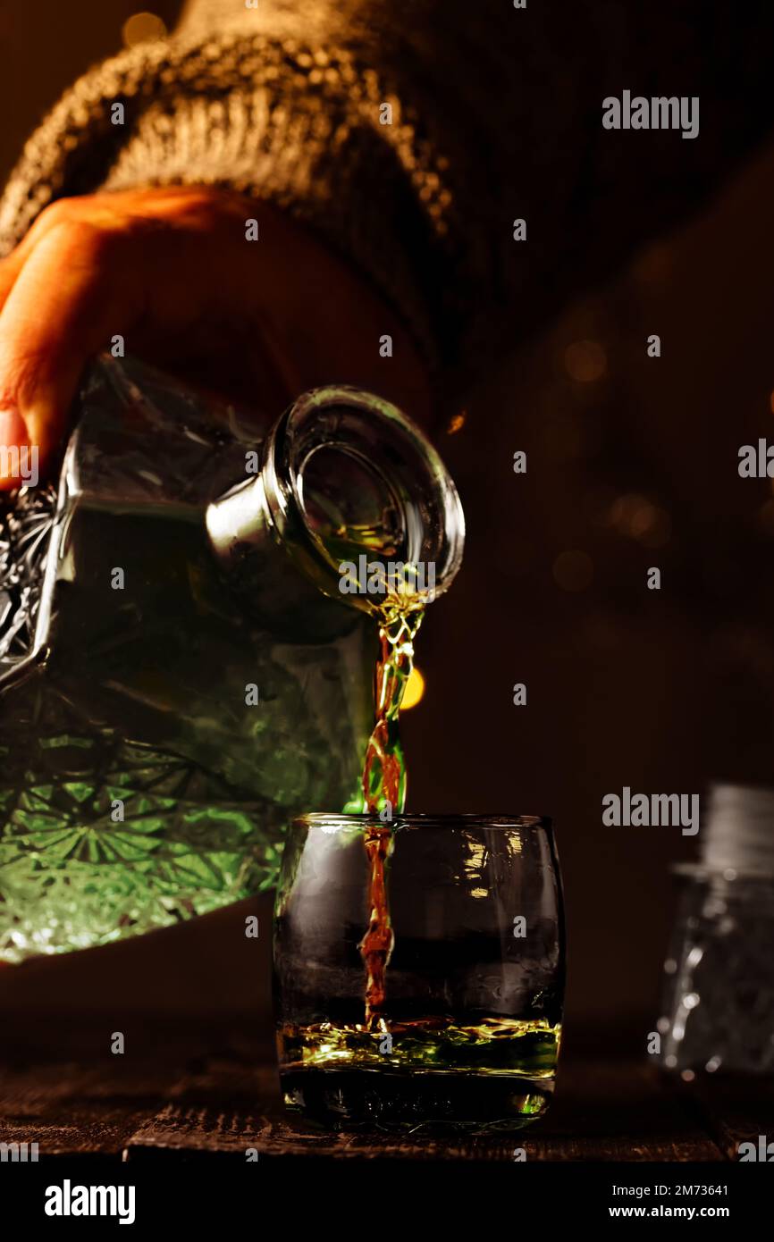 A vertical shot of pouring alcohol from the bottle into the glass Stock ...