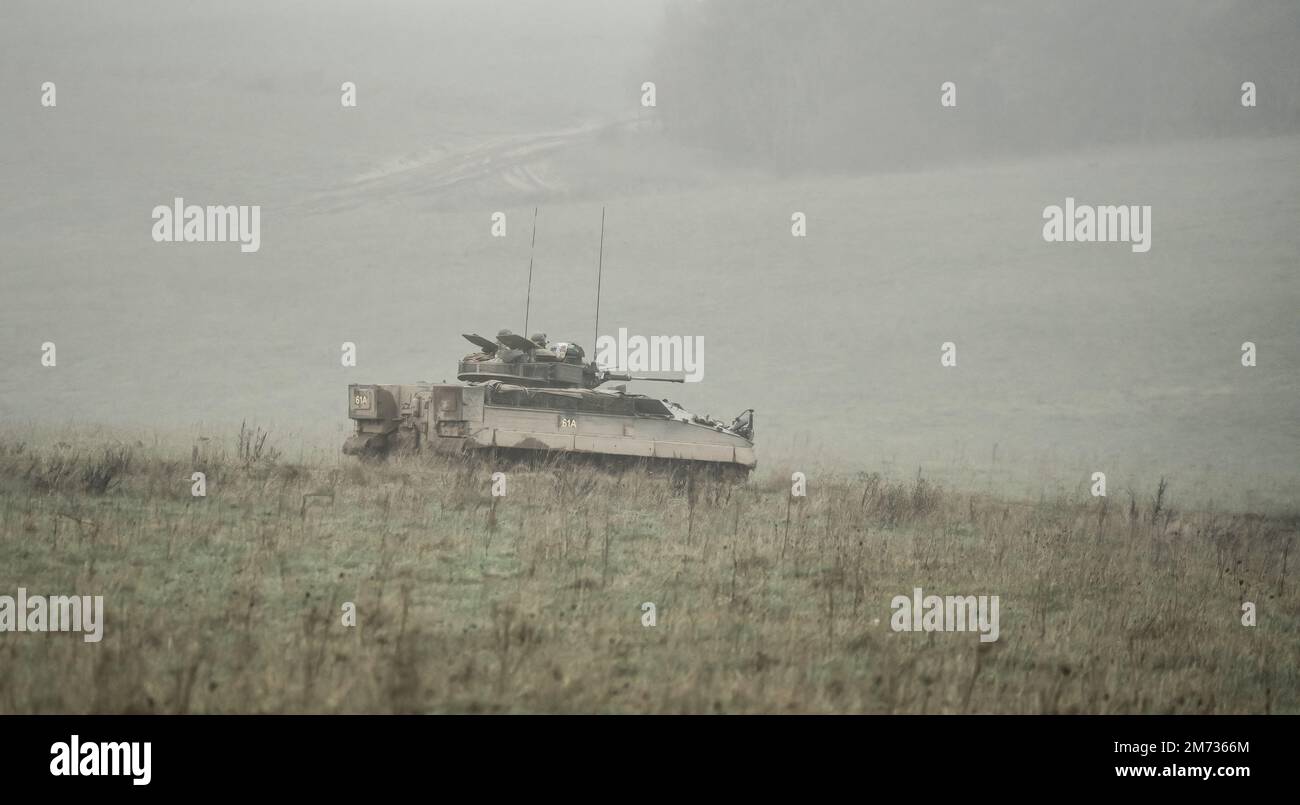 side profile of commander and gunner directing a British army Warrior ...