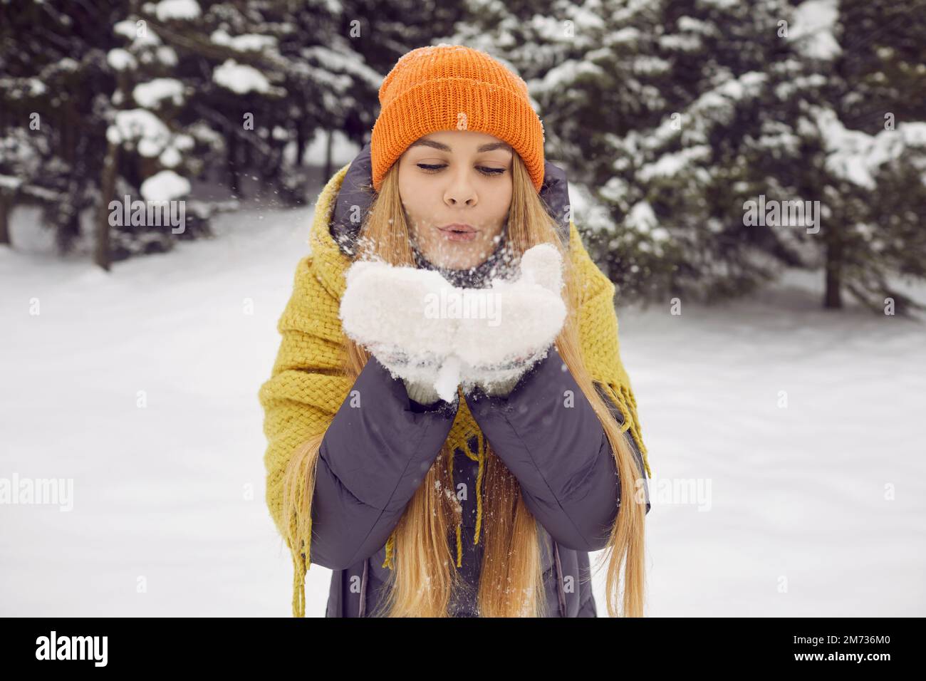 Portrait of beautiful young woman blowing snow from her palms during winter walk Stock Photo - Alamy