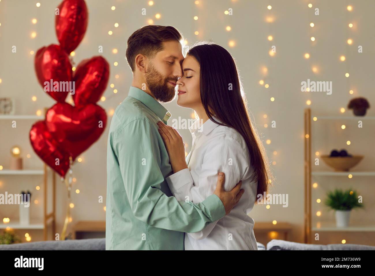 Portrait of young couple in love who are tenderly hugging during ...