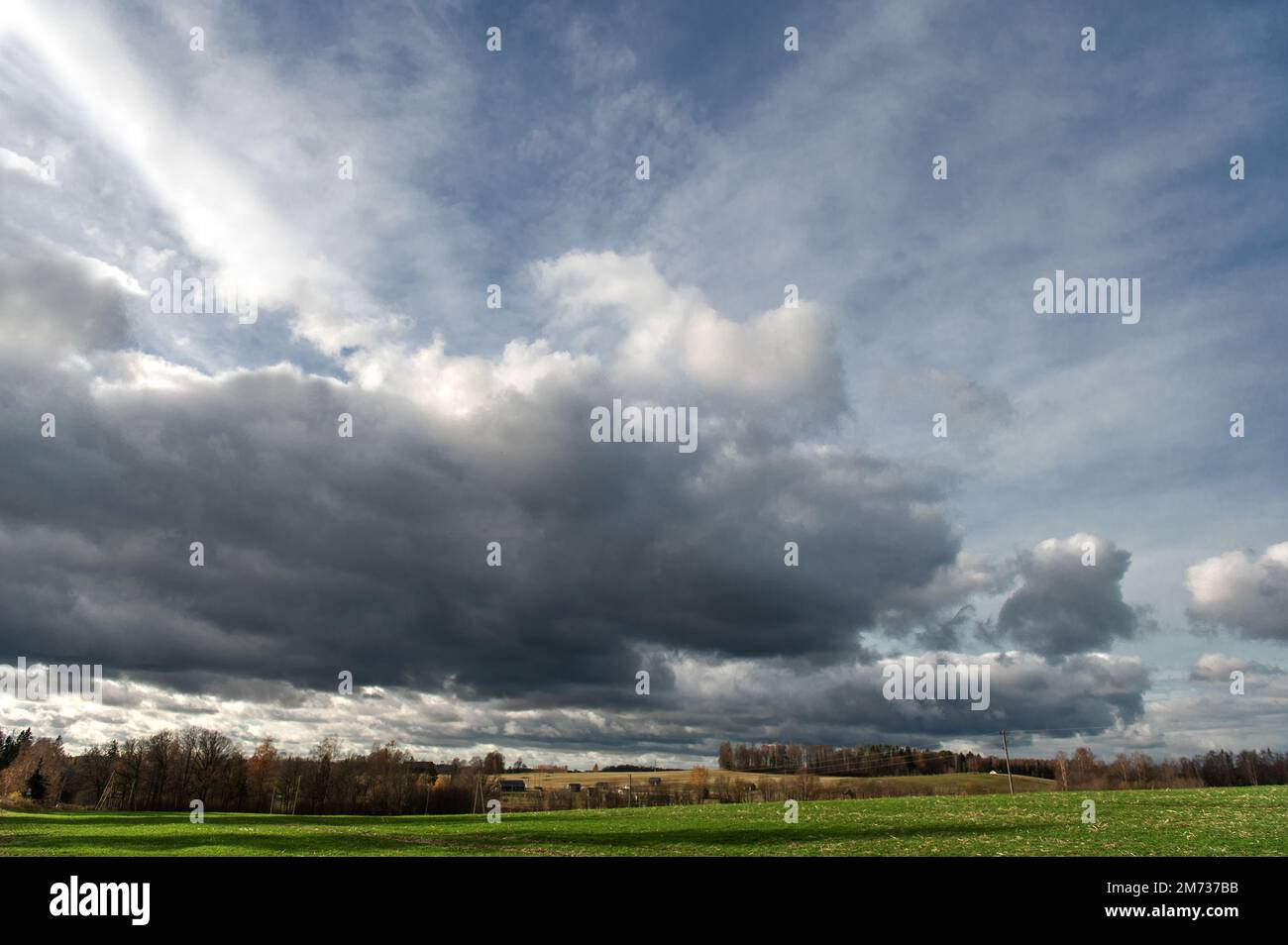 Dramatic sky with dark rain clouds over of autumnal country landscape ...
