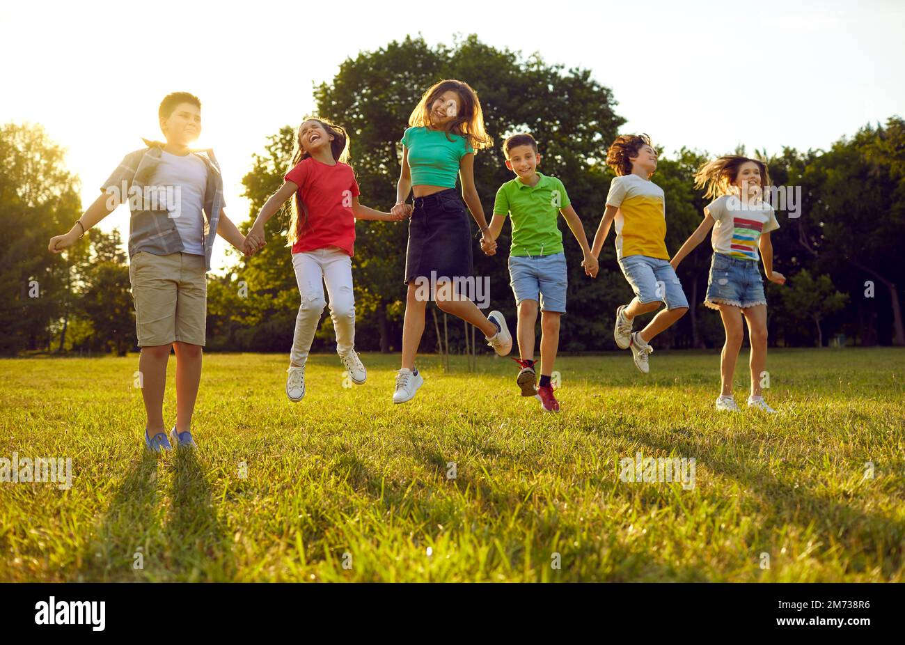 Funny childrens boys and girls simultaneously jumping holding hands ...