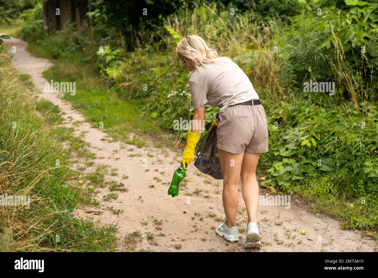woman picking up garbage and putting it in plastic black bag Stock ...