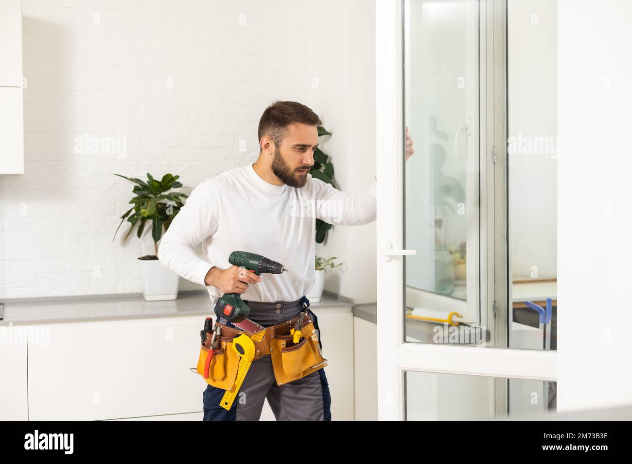 service man installing window with screwdriver Stock Photo - Alamy