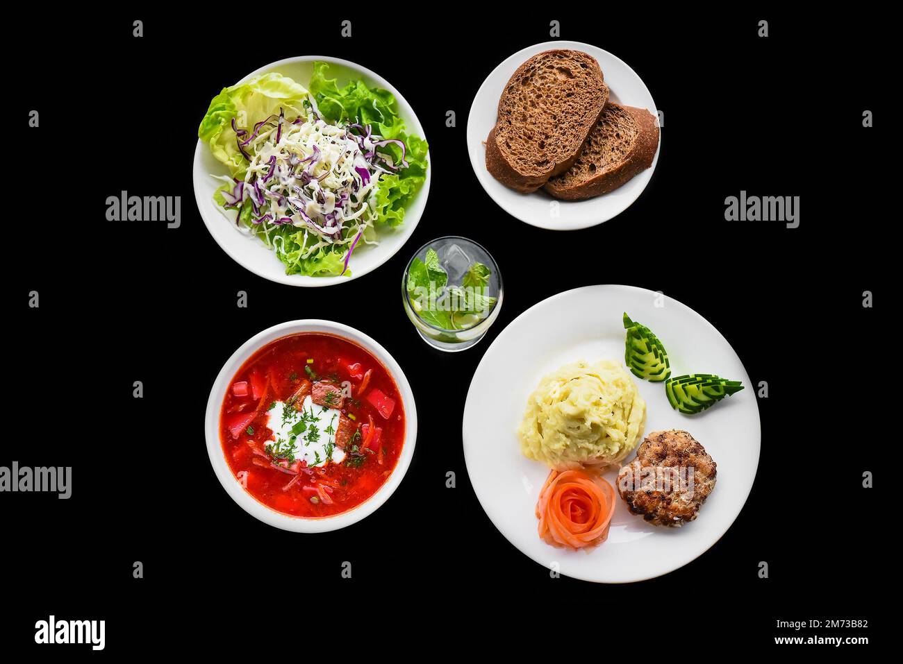 Combo set with borscht, mashed potato, black bread, salad on black ...