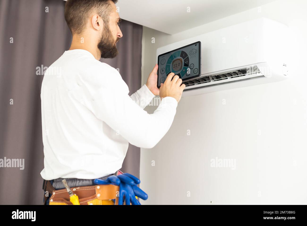 male technician service worker diagnosing for repairs air conditioner ...