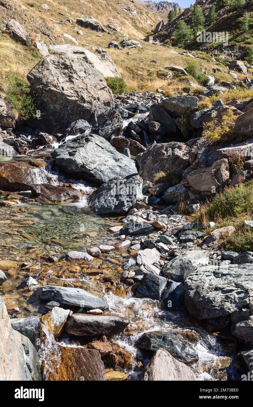 Small pond of clear water with pebbles, sand and cobblestones between ...