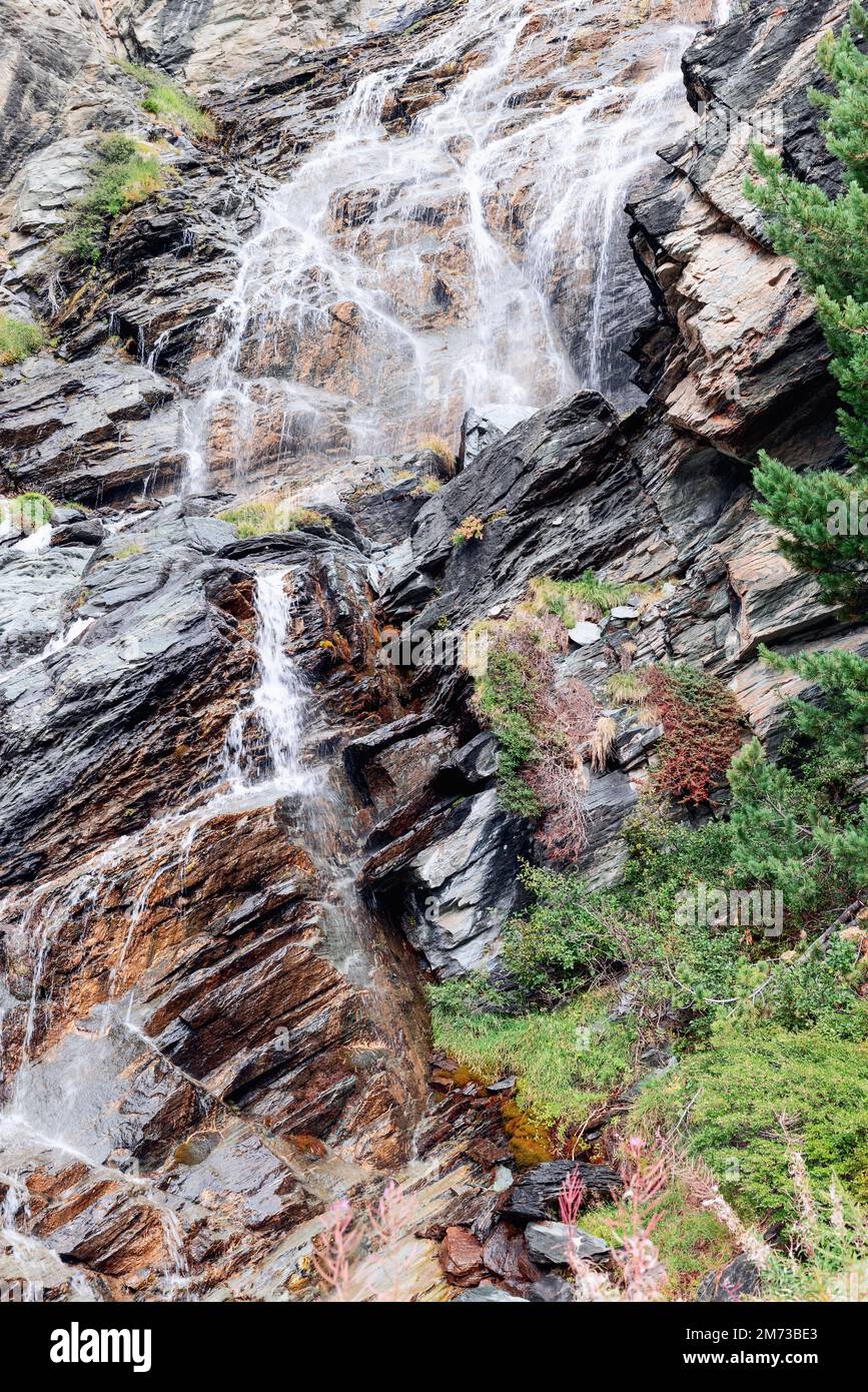 Alpine flowing waterfall washes various color karst overlays of granite ...