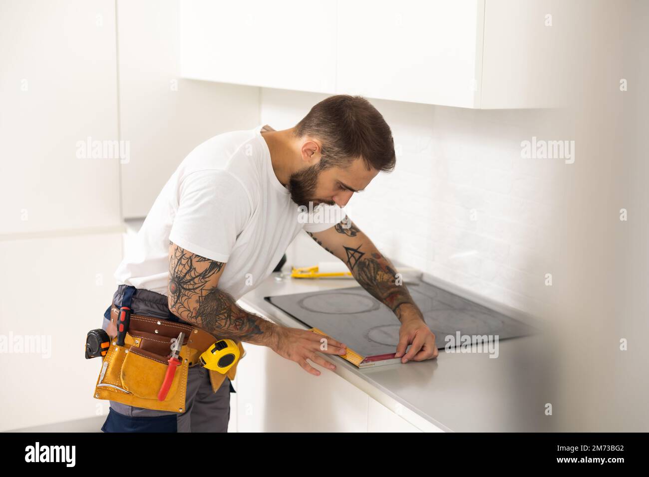 Man electrical repairs kitchen surface apartment. Installing hob in ...