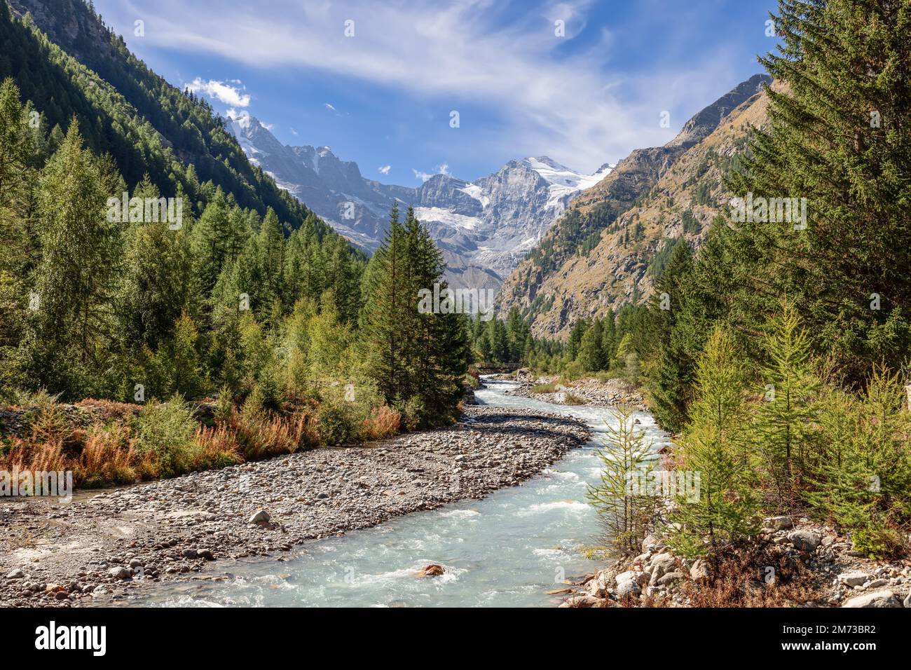 Stormy Alpine mountain water stream runs along gorge rapids, covered ...