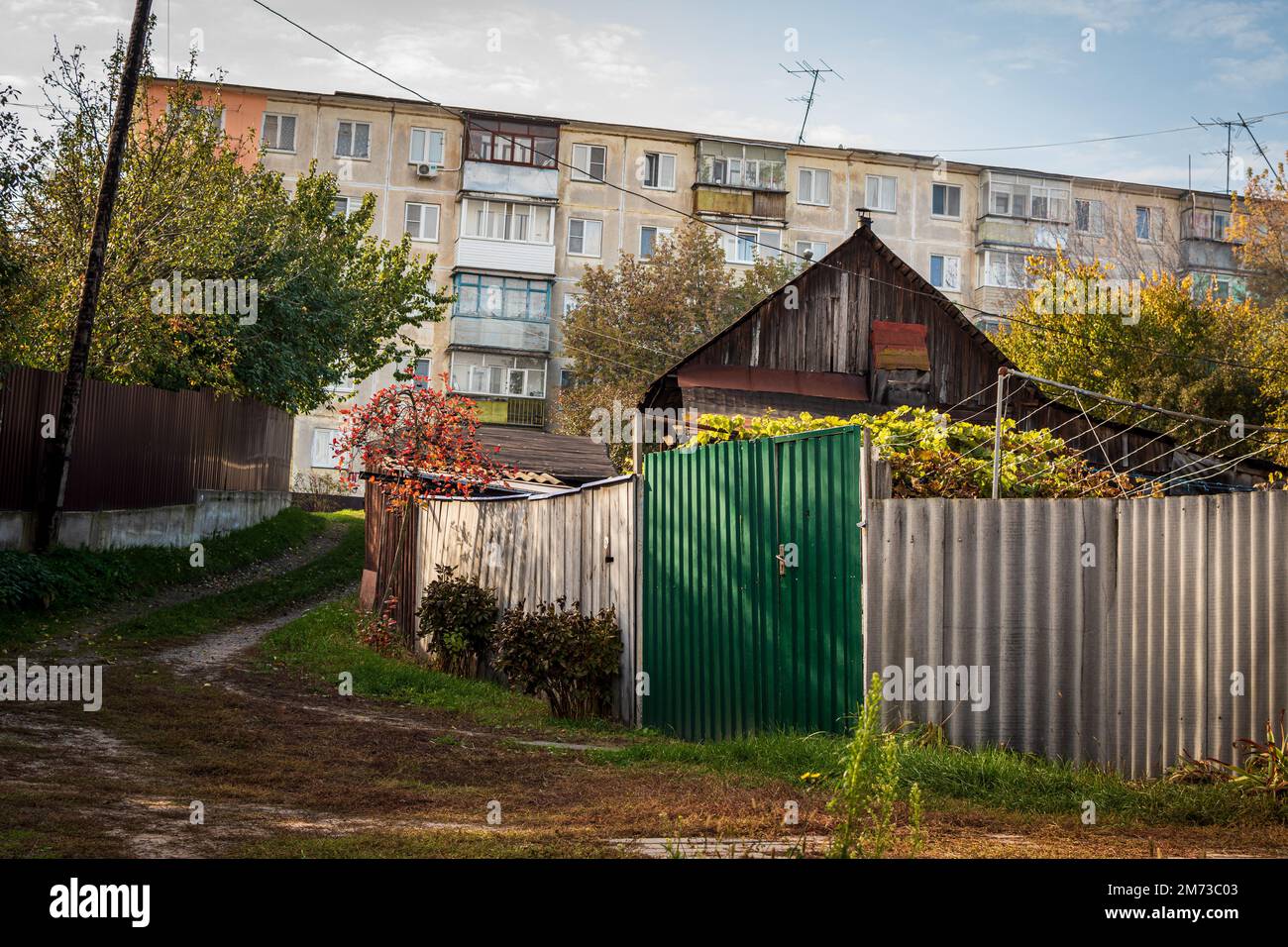 An old house against the background of the Soviet apartment building in ...