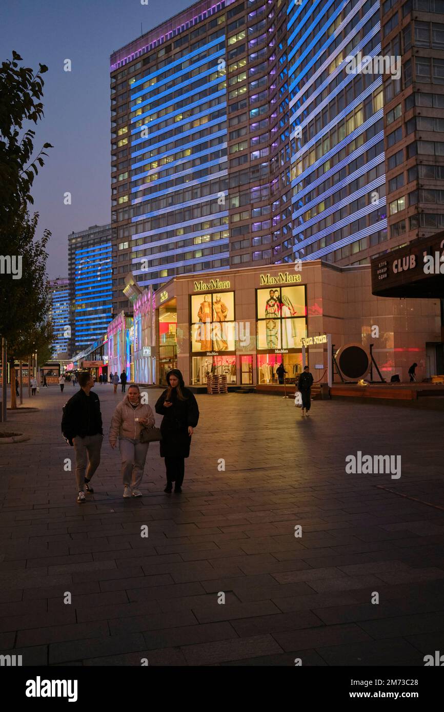 People walk along the sidewalk at dusk. Novy Arbat (New Arbat) street ...