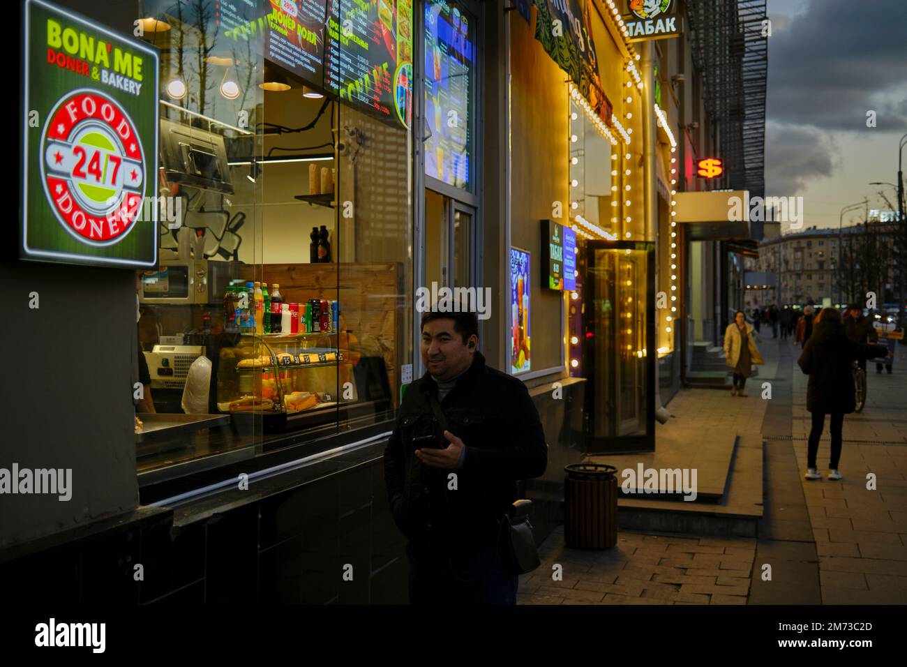 A man waits for his order at a fast food stall. Smolenskiy Bulvar ...
