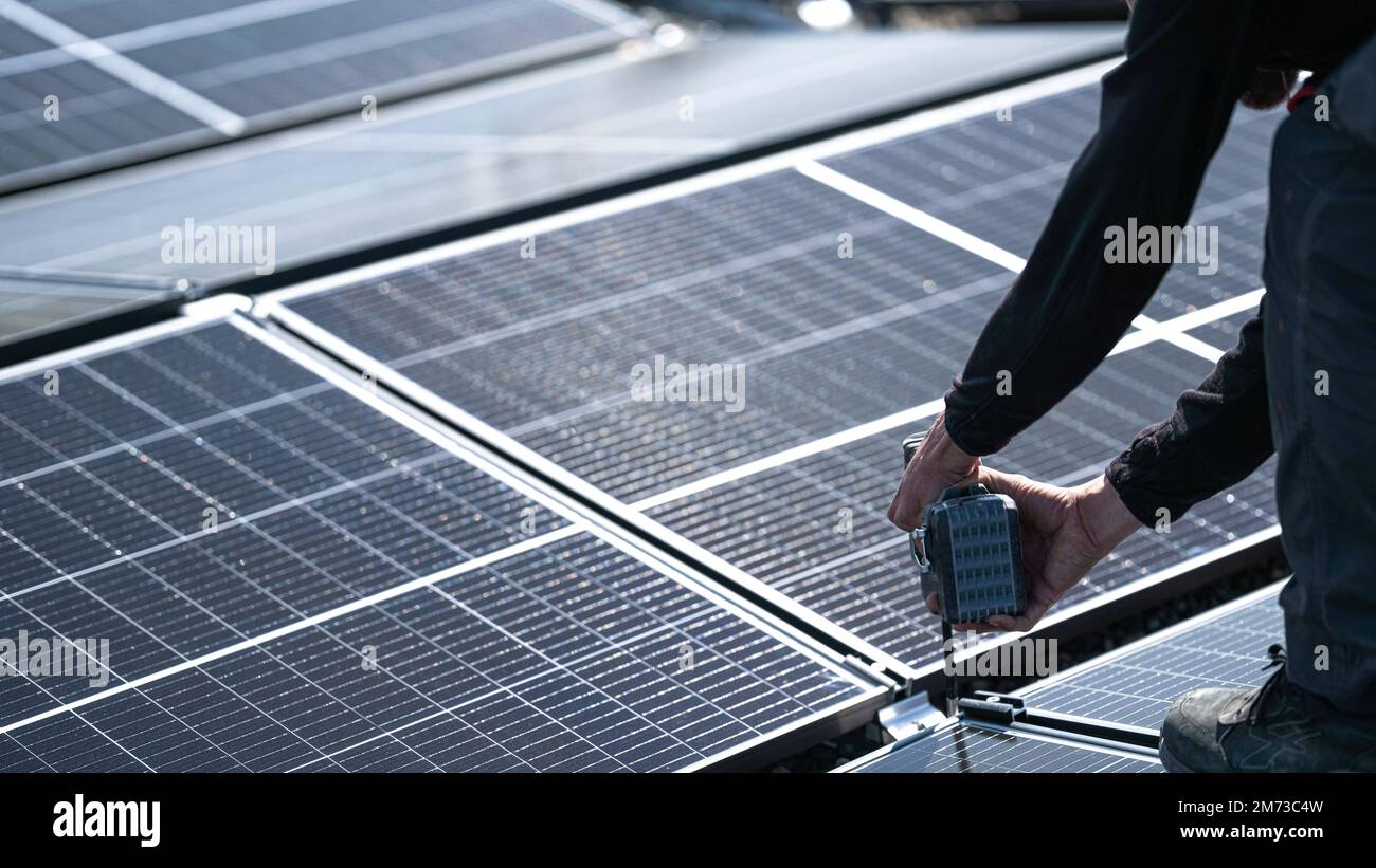 Male team engineers installing stand-alone solar photovoltaic panel ...