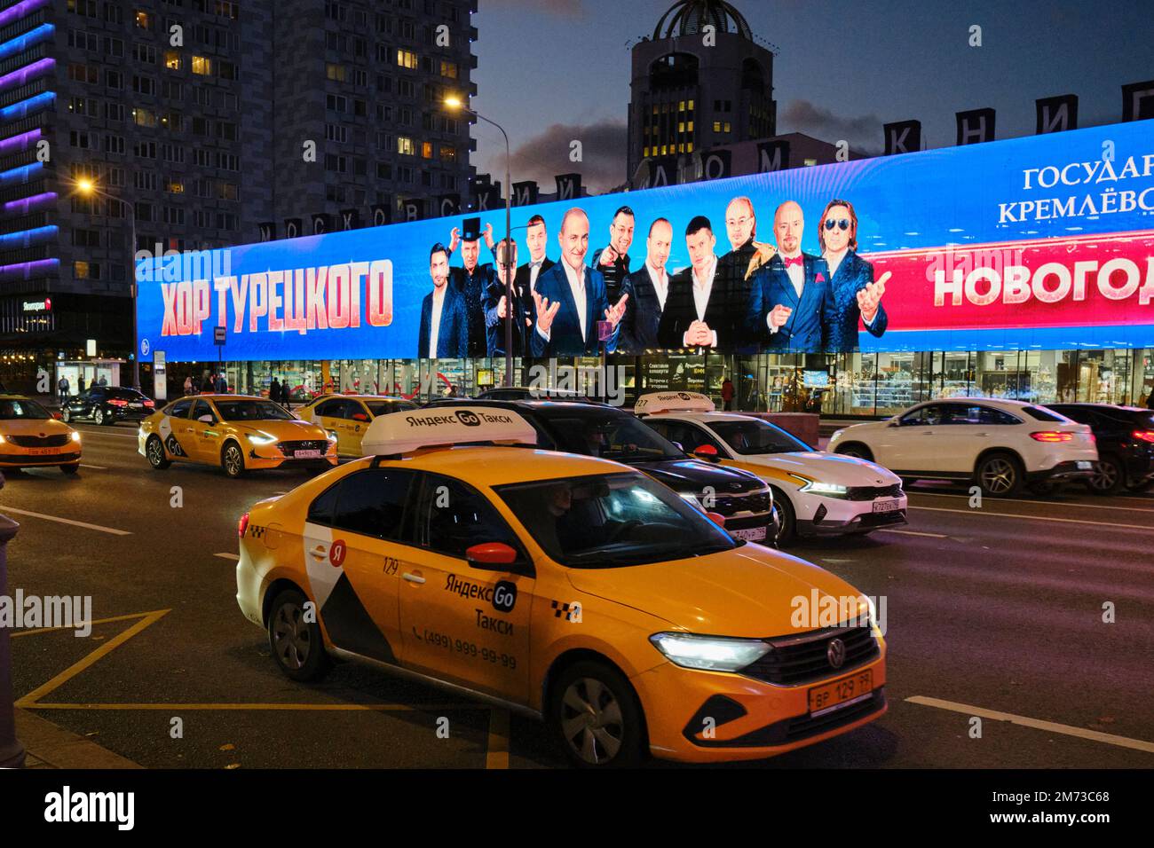 Yellow taxicab moving along the Novy Arbat (New Arbat) street at dusk ...