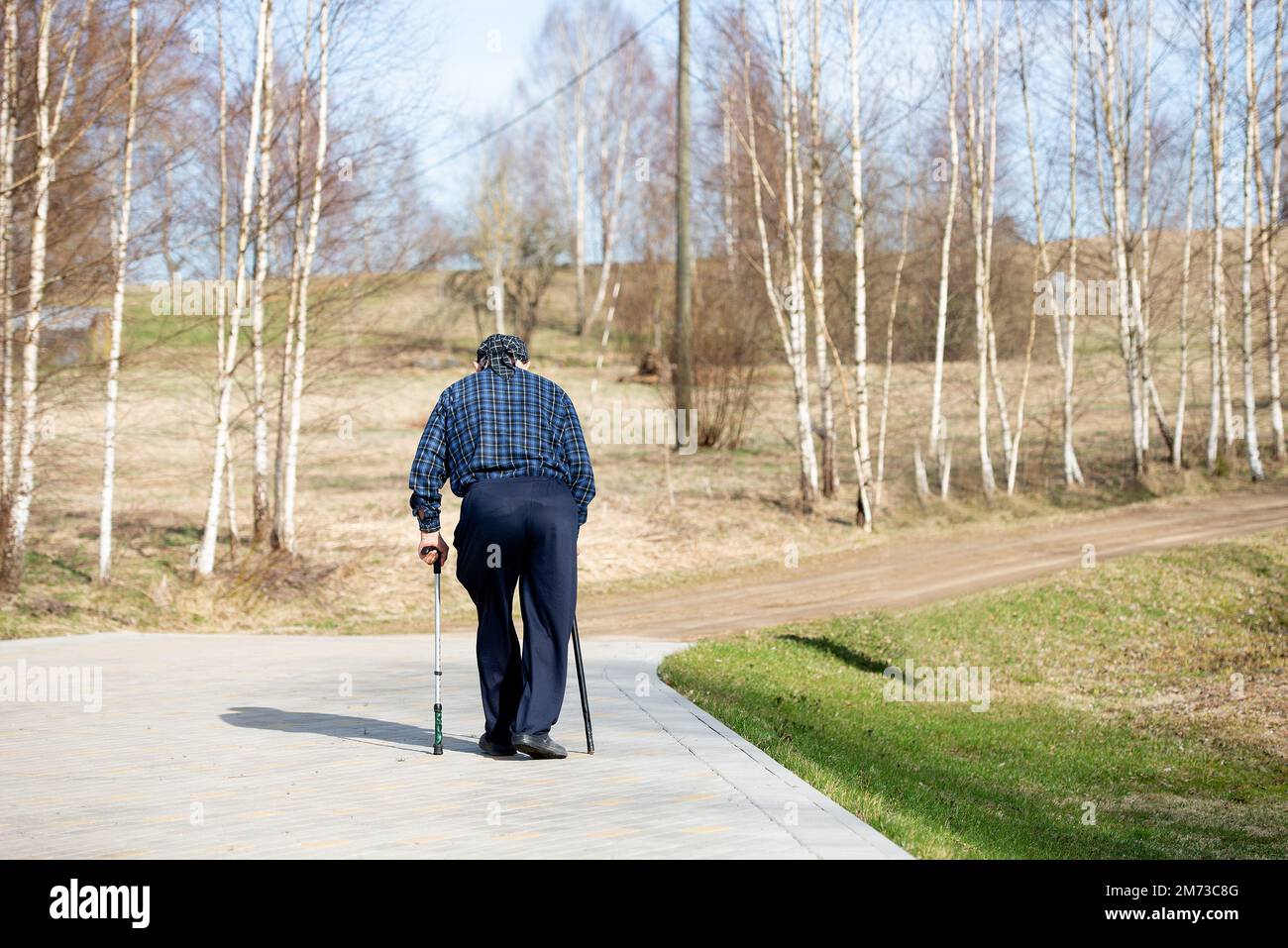 Rear view of a man walking with a stick hi-res stock photography and ...