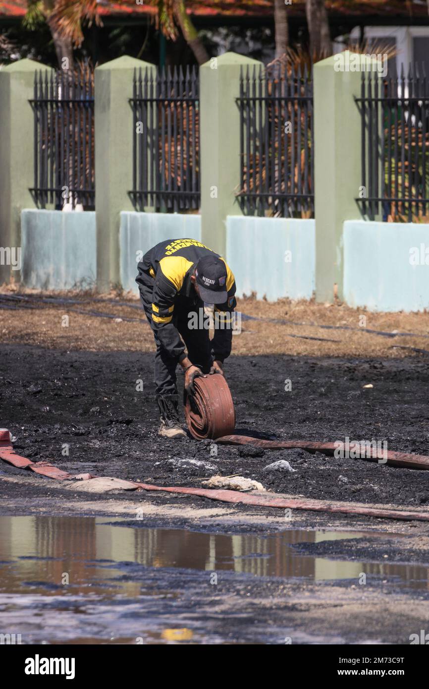 A firefighter collecting accessories after putting out a fire in ...