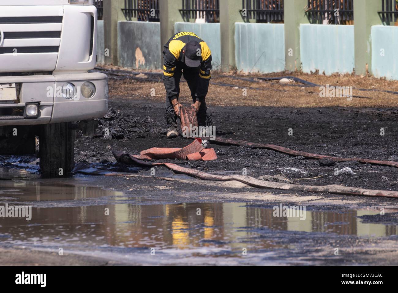 A firefighter collecting accessories after putting out a fire in ...