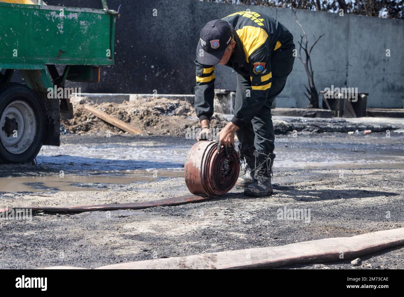 A firefighter collecting accessories after putting out a fire in ...
