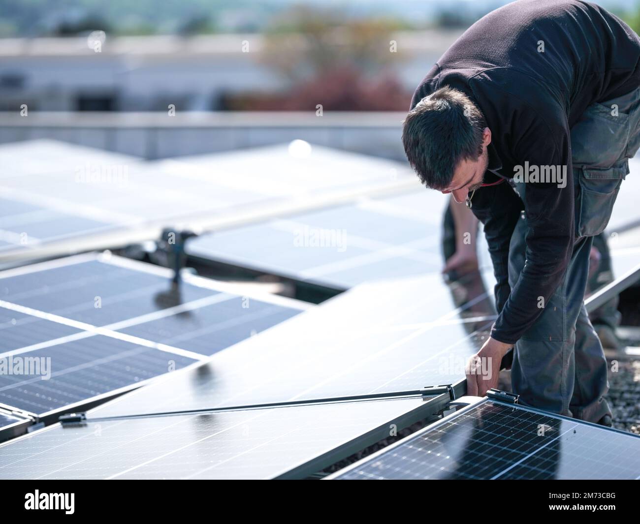 Male team engineers installing stand-alone solar photovoltaic panel ...