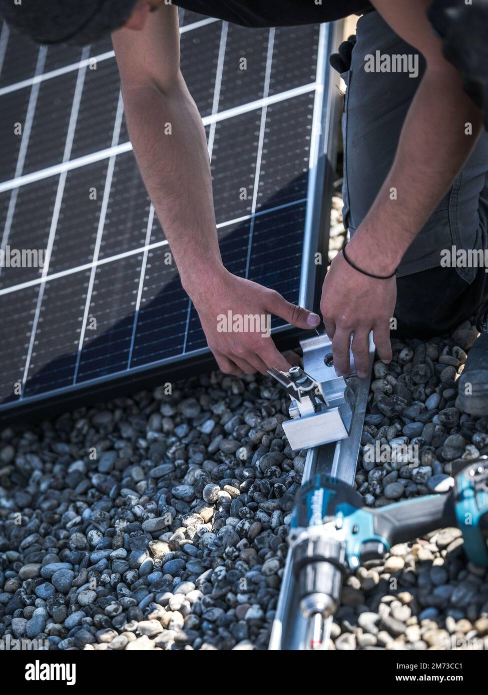 Male team engineers installing stand-alone solar photovoltaic panel ...