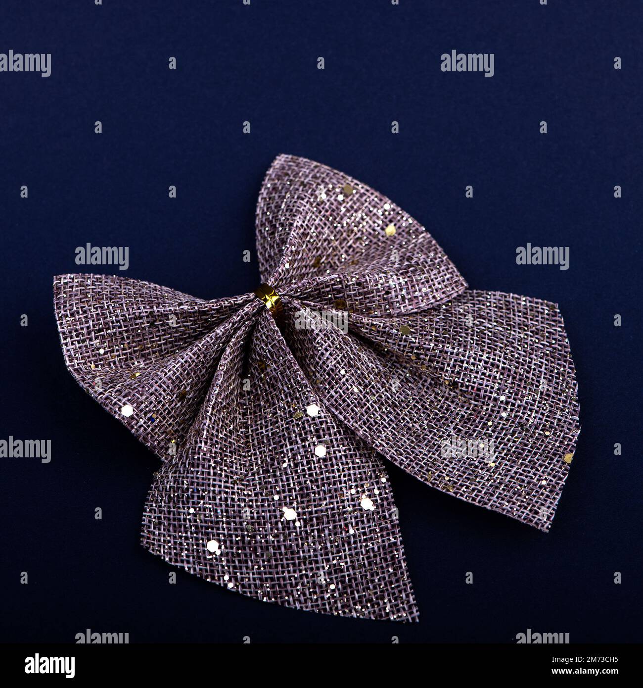 Burlap bow with gold glitter on dark blue background, Christmas holiday ...