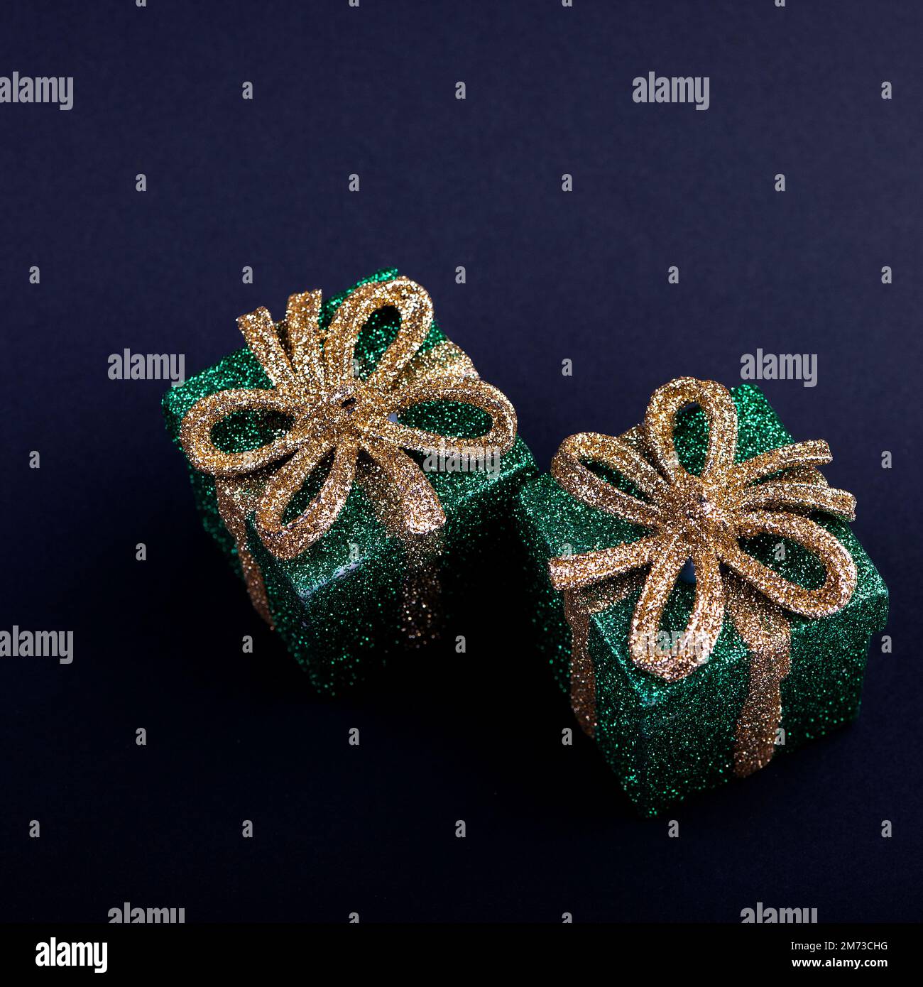 Christmas decor green gift boxes with shiny gold bow on dark square ...