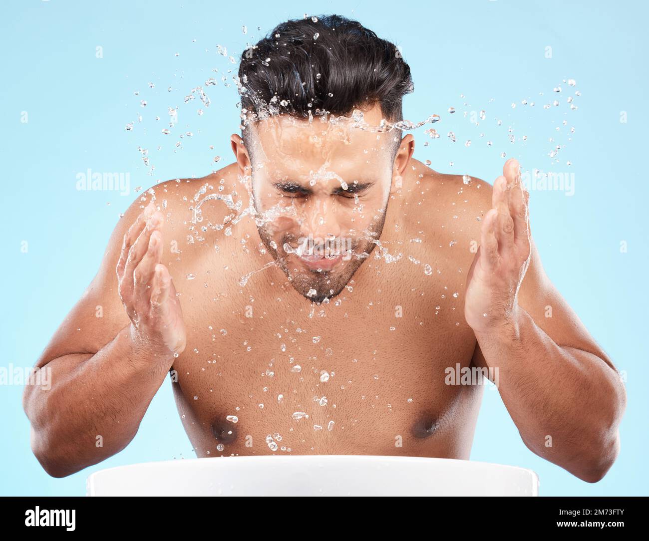 Face, water splash and skincare of man cleaning in studio isolated on a ...