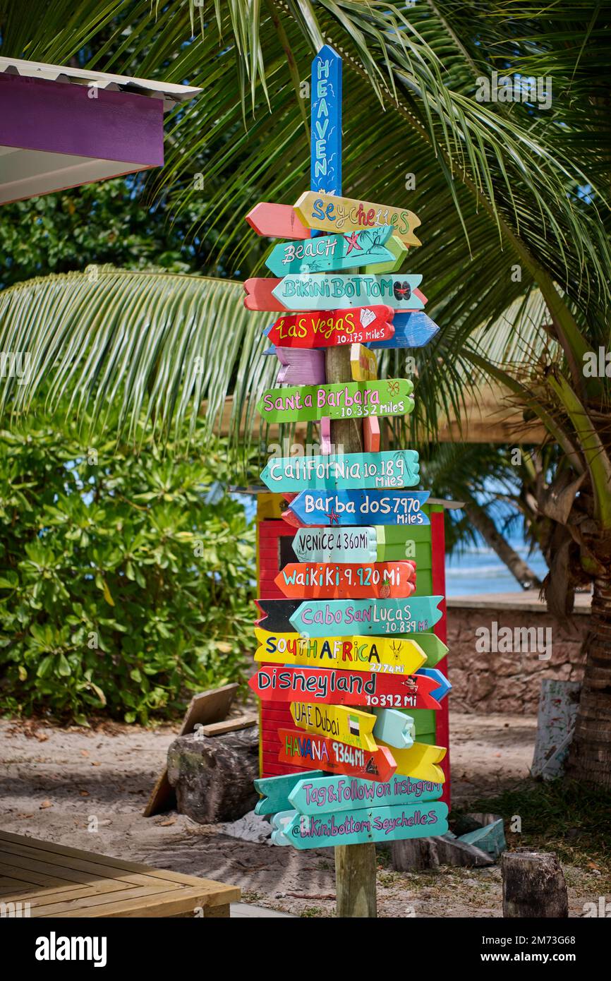 colorful information signs with distances to places around the world on ...